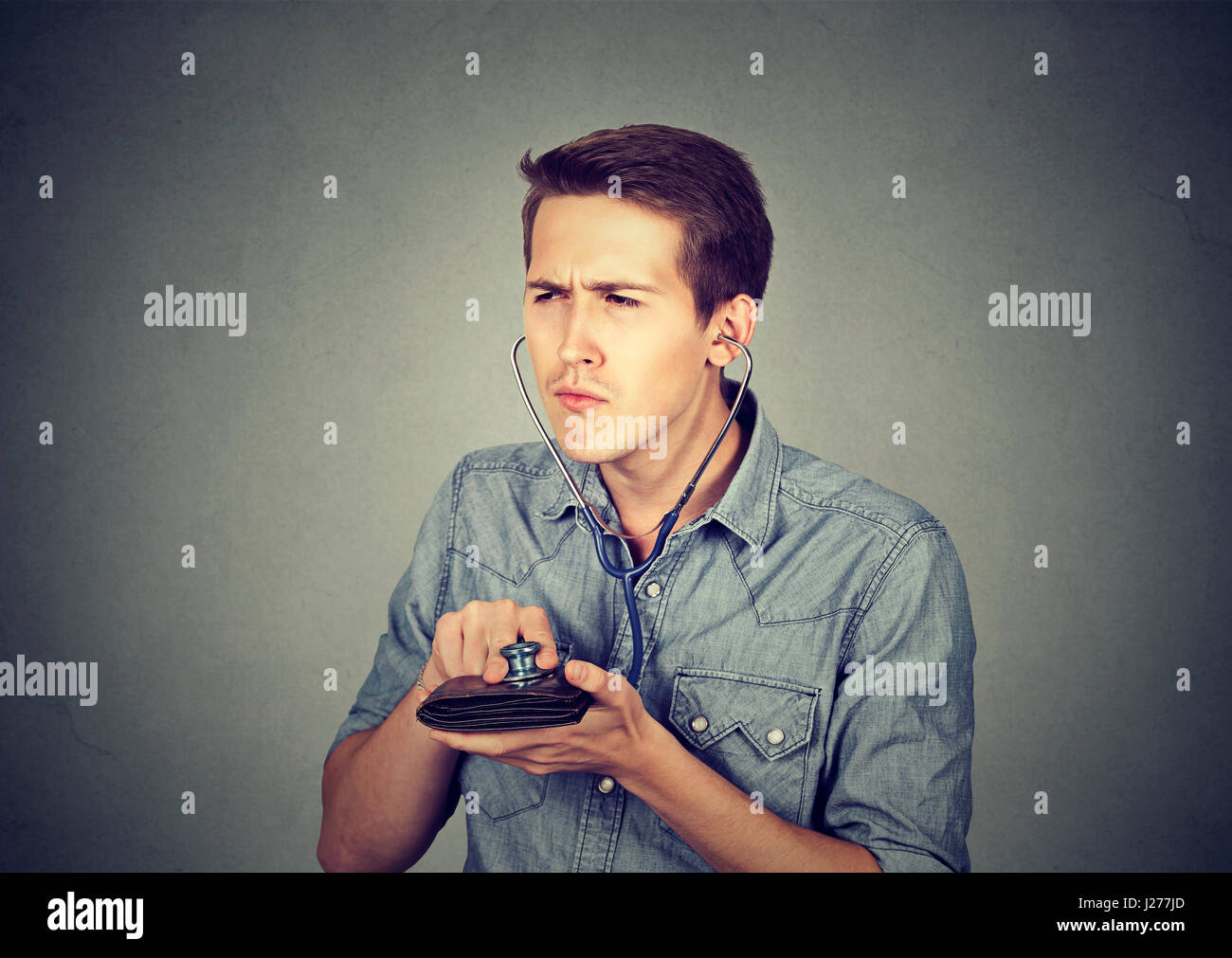 Preoccupied young man checking wallet with stethoscope. Concept of ...
