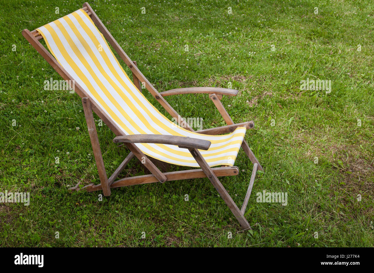 Vintage striped collapsible garden chair on the lawn Stock Photo - Alamy