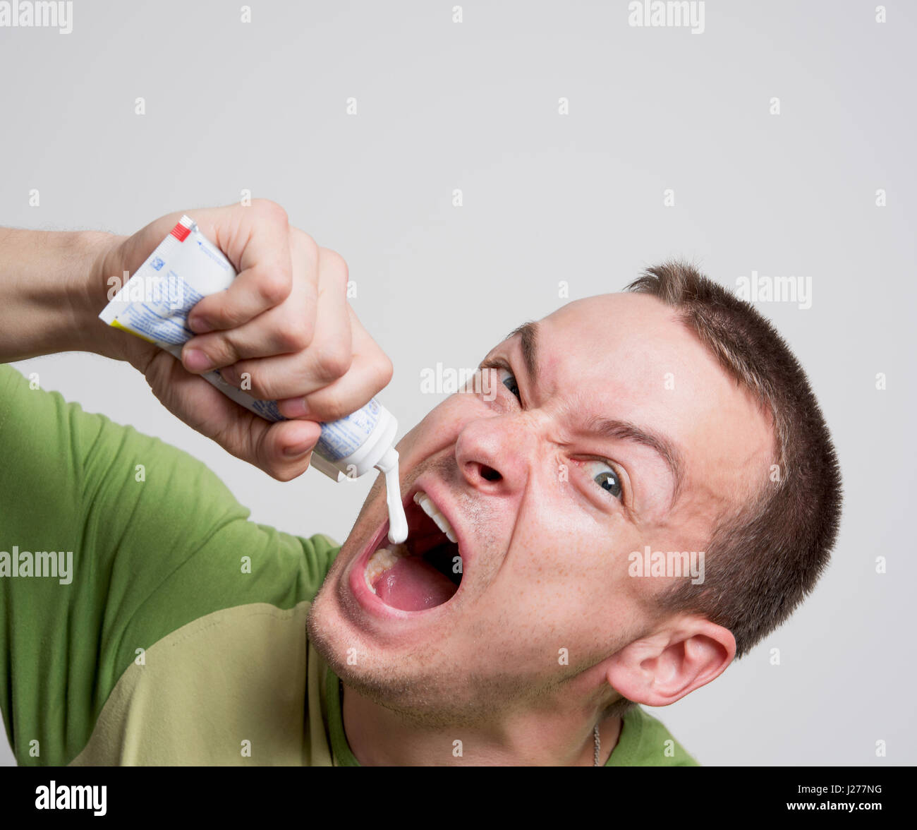 man squeezes the toothpaste in the mouth Stock Photo - Alamy