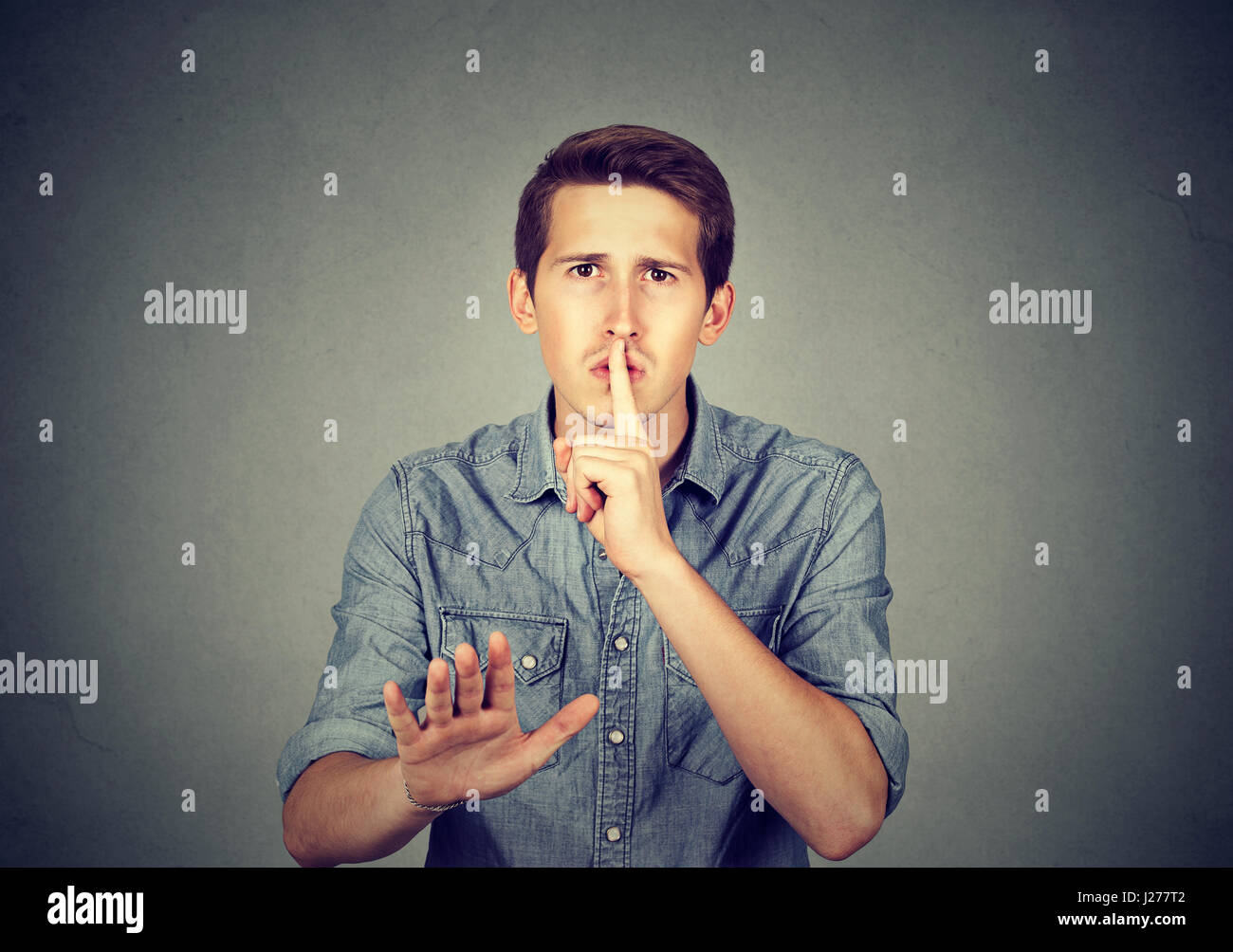 young handsome man giving Shhhh quiet, silence, secret gesture isolated ...