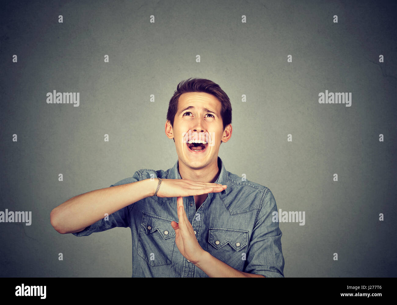 Young man showing time out hand gesture, frustrated screaming. Human ...