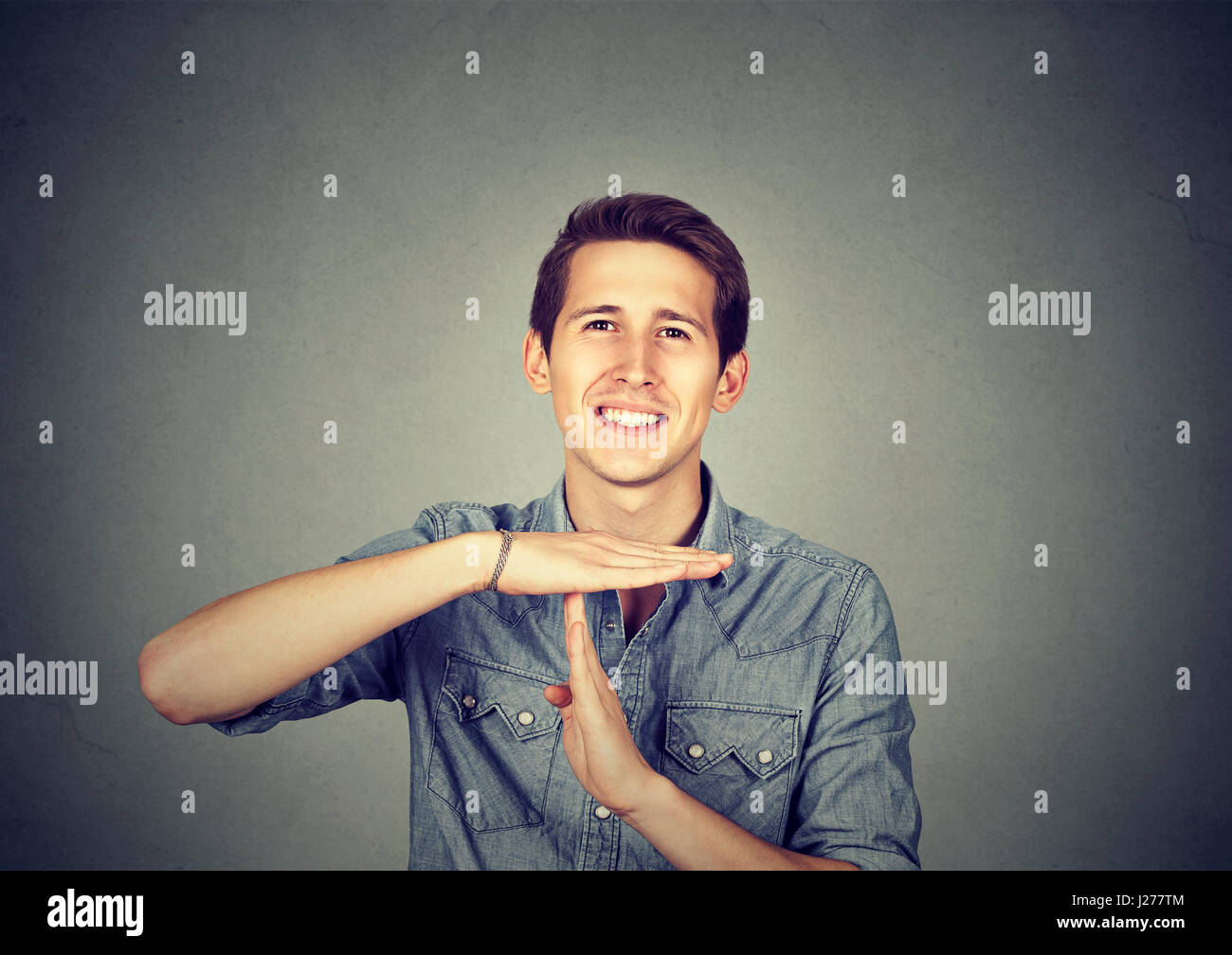 happy man giving time out hand gesture isolated on gray wall background ...