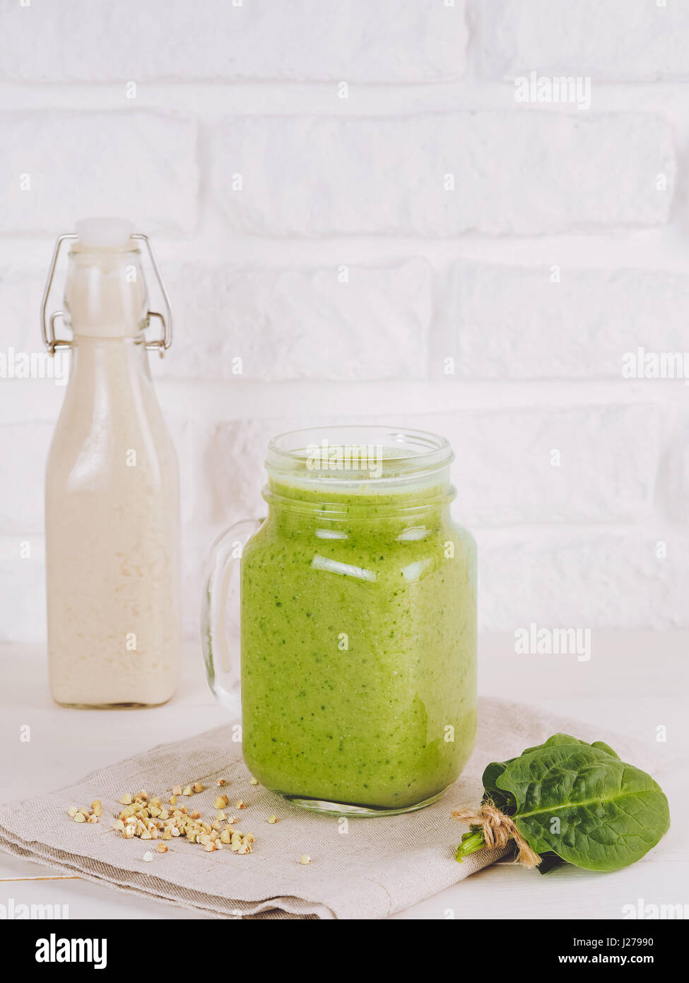 Close up view of green smoothie in mason jar on white table. Fresh ...