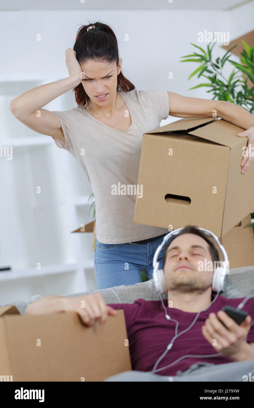 Busy woman frustrated with lazy boyfriend Stock Photo - Alamy