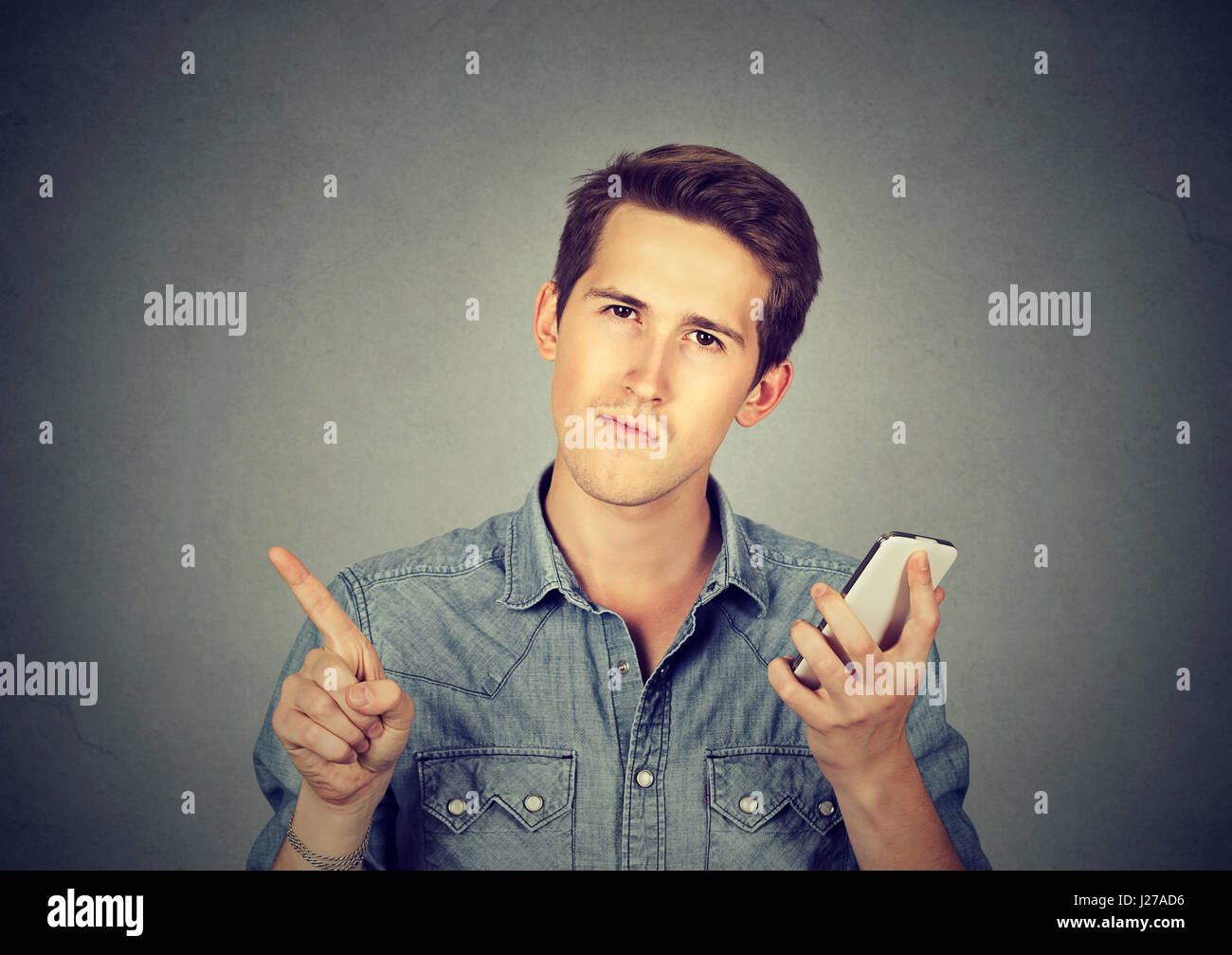 Young man with smartphone. Handsome guy holding cell phone showing no ...