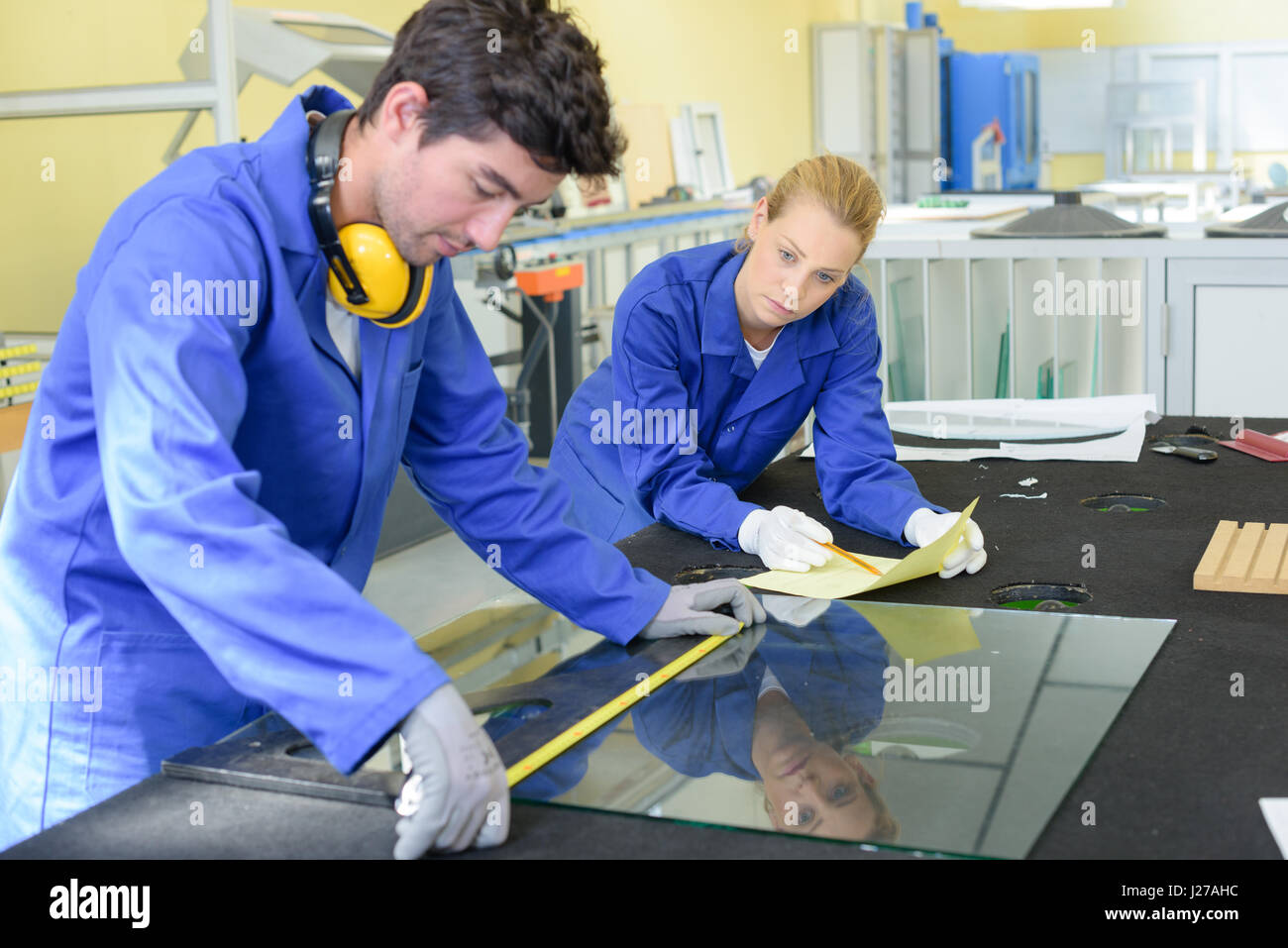 Young man measuring pane of glass Stock Photo - Alamy