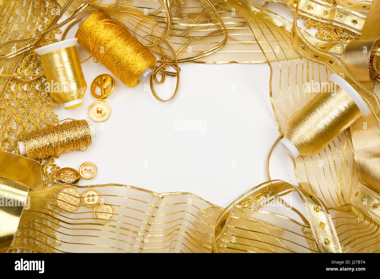 Studio shot of gold sewing items, buttons, ribbons, thread isolated on ...