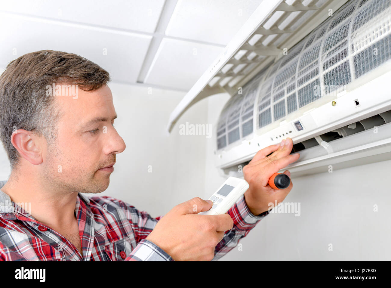 Man checking air conditioning unit Stock Photo - Alamy