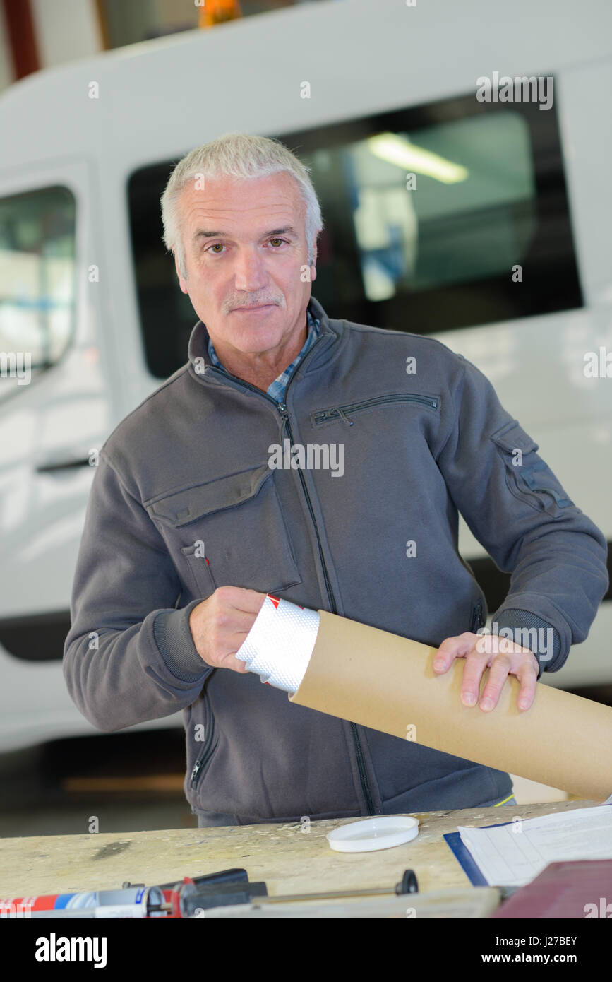 Worker taking paper from cardboard roll Stock Photo - Alamy