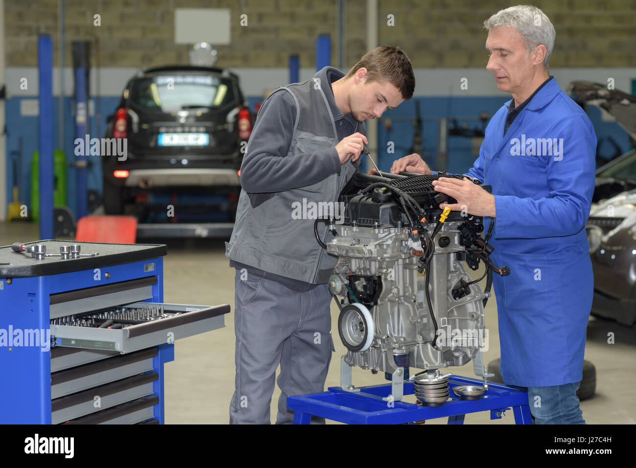 apprentice mechanic in auto shop working on car engine Stock Photo - Alamy