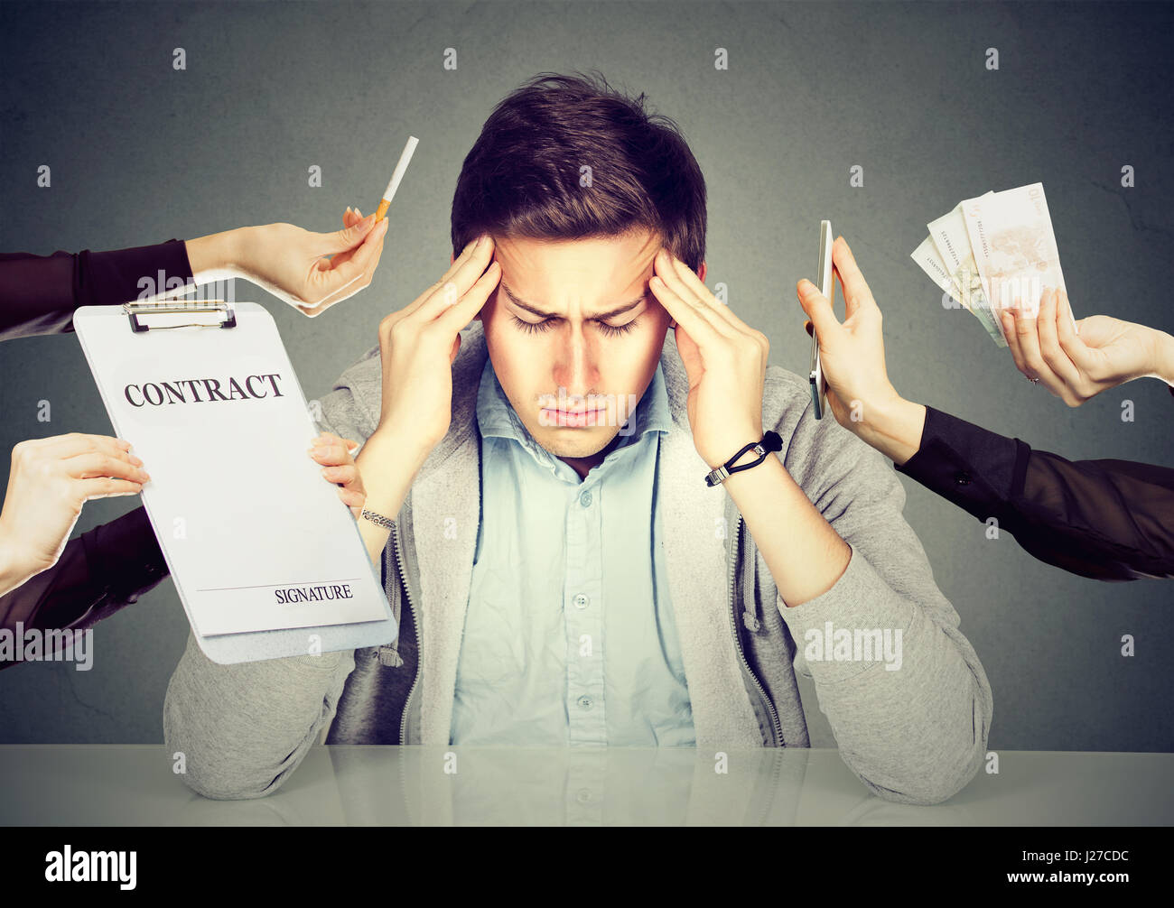 Desperate sad young man leaning on a desk. Stressed guy overwhelmed by ...