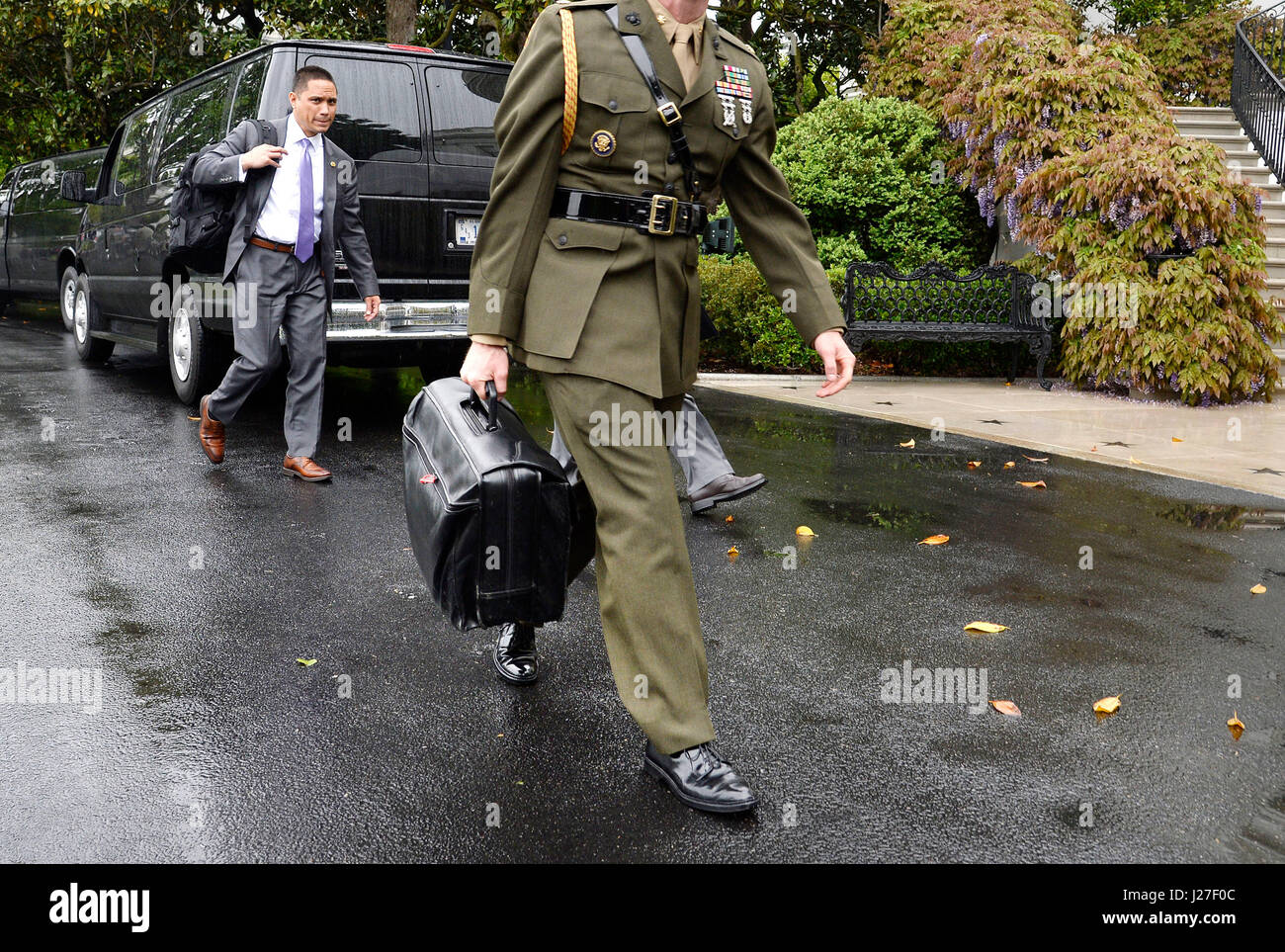 A military aide carries the "nuclear football" on the South Lawn of the ...