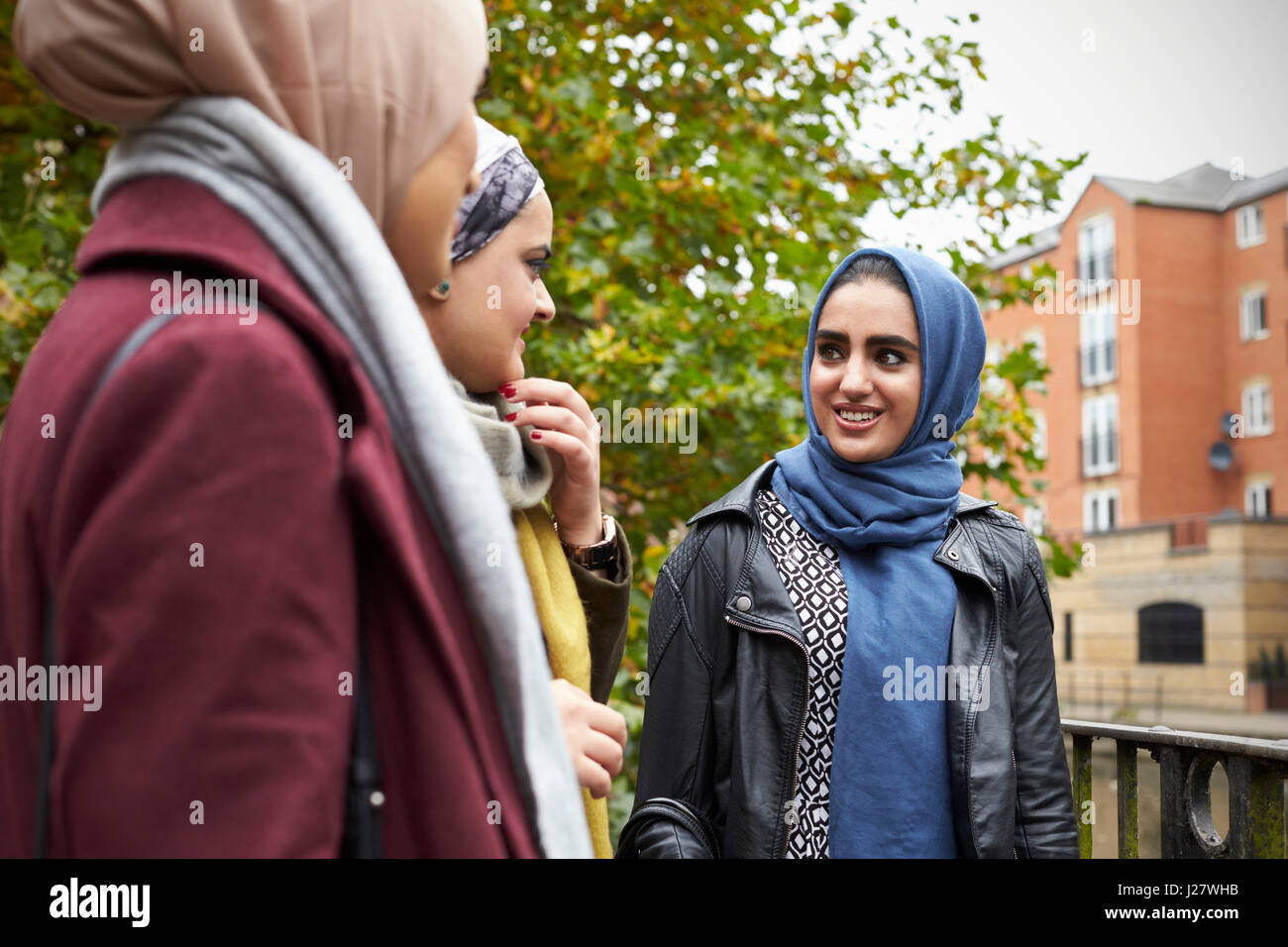 British Muslim Female Friends Meeting In Urban Environment Stock Photo ...