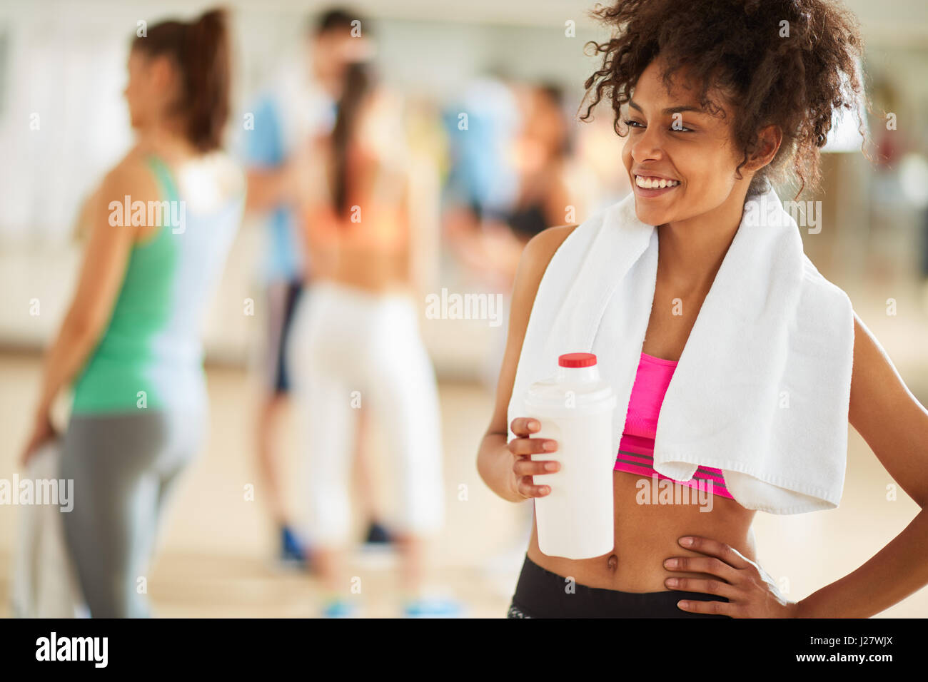 Happy young half-caste girl drink protein shake after training in ...