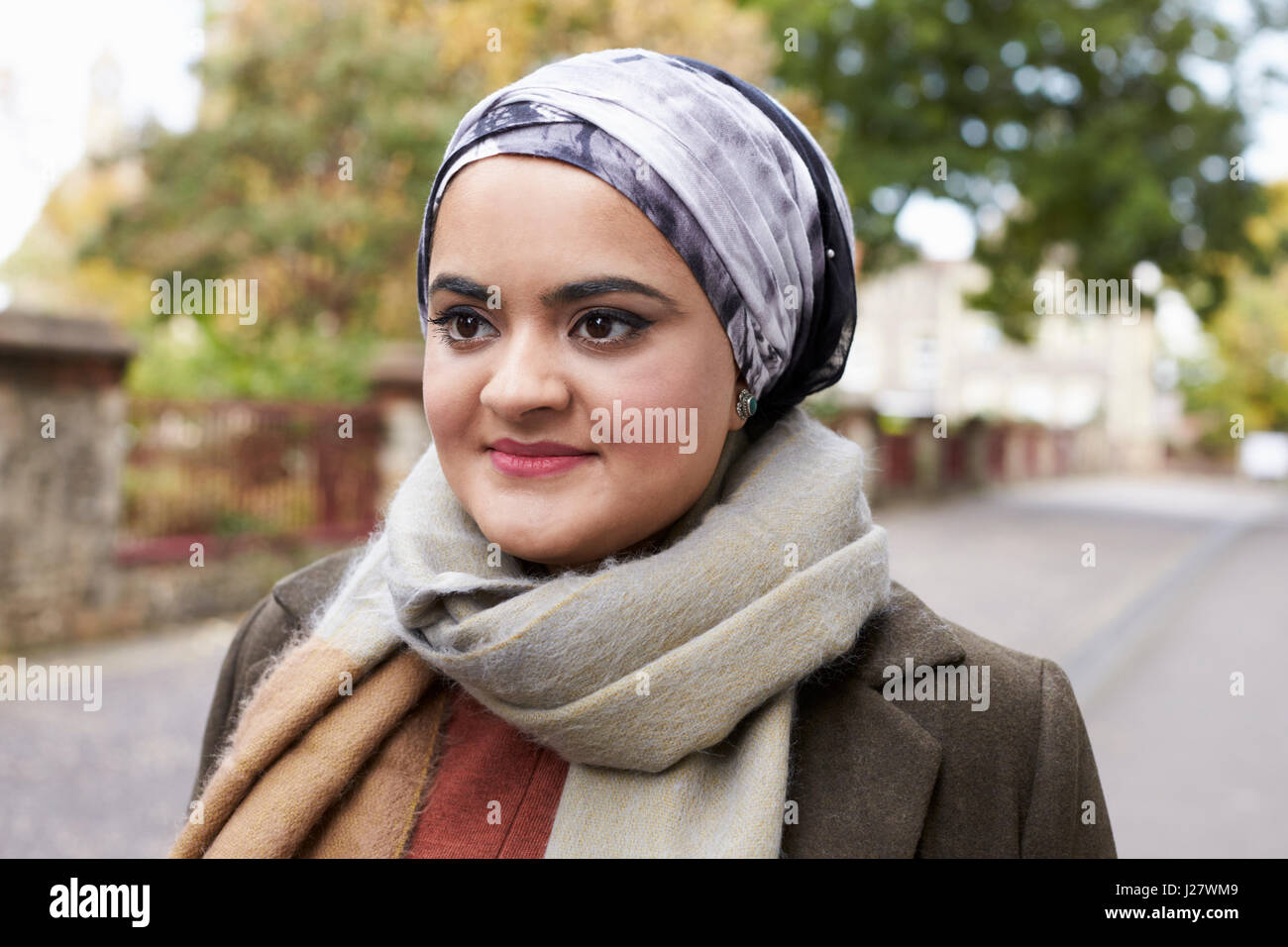 British Muslim Woman Walking On Street In Urban Environment Stock Photo ...