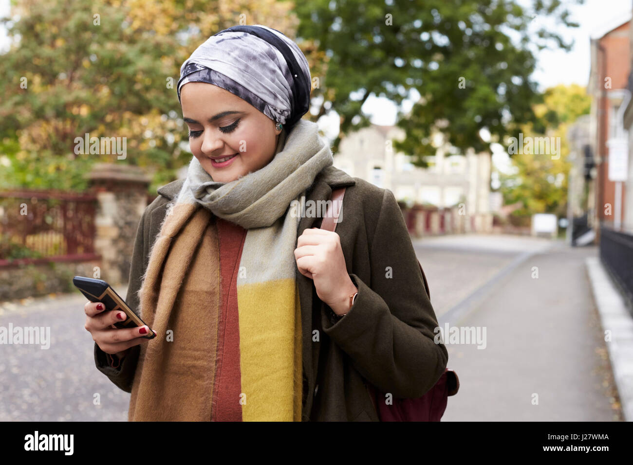 British Muslim Woman Using Mobile Phone In Urban Setting Stock Photo ...