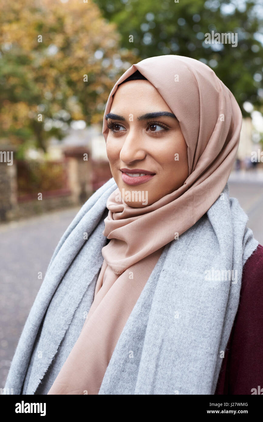 British Muslim Woman Walking On Street In Urban Environment Stock Photo ...