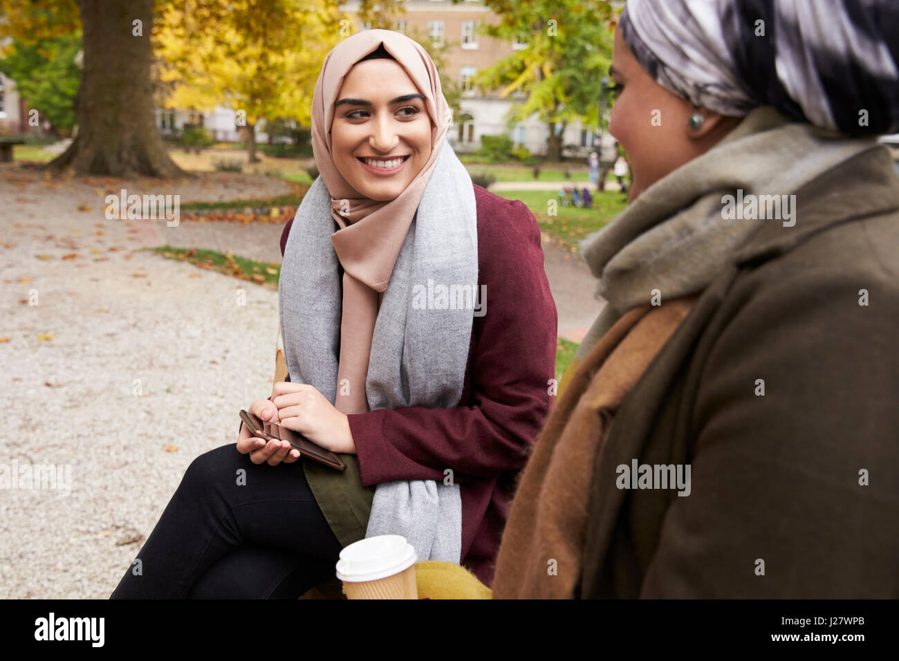 Two British Muslim Women Eating Lunch In Park Together Stock Photo - Alamy