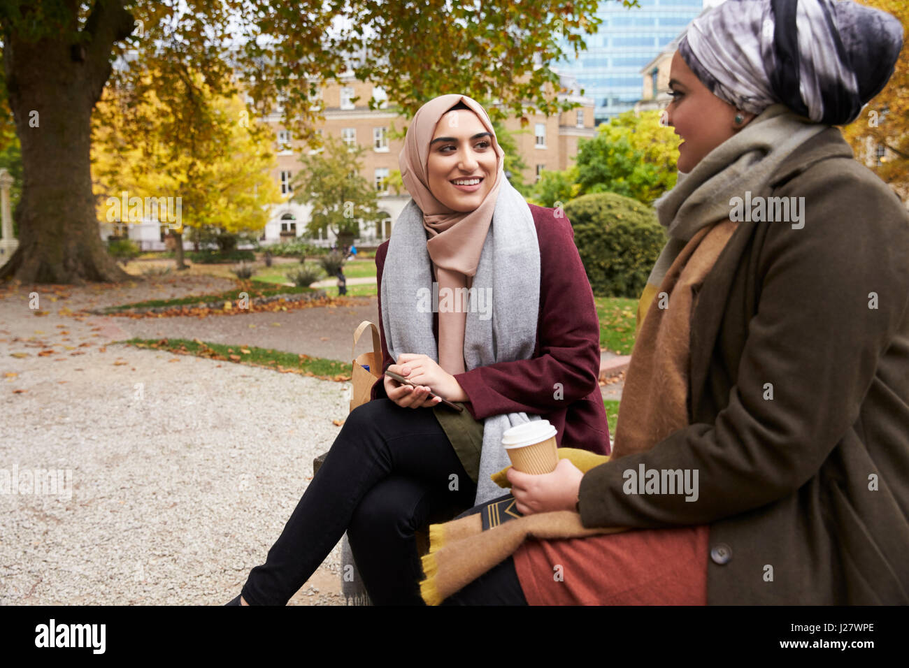 Two British Muslim Women Eating Lunch In Park Together Stock Photo - Alamy