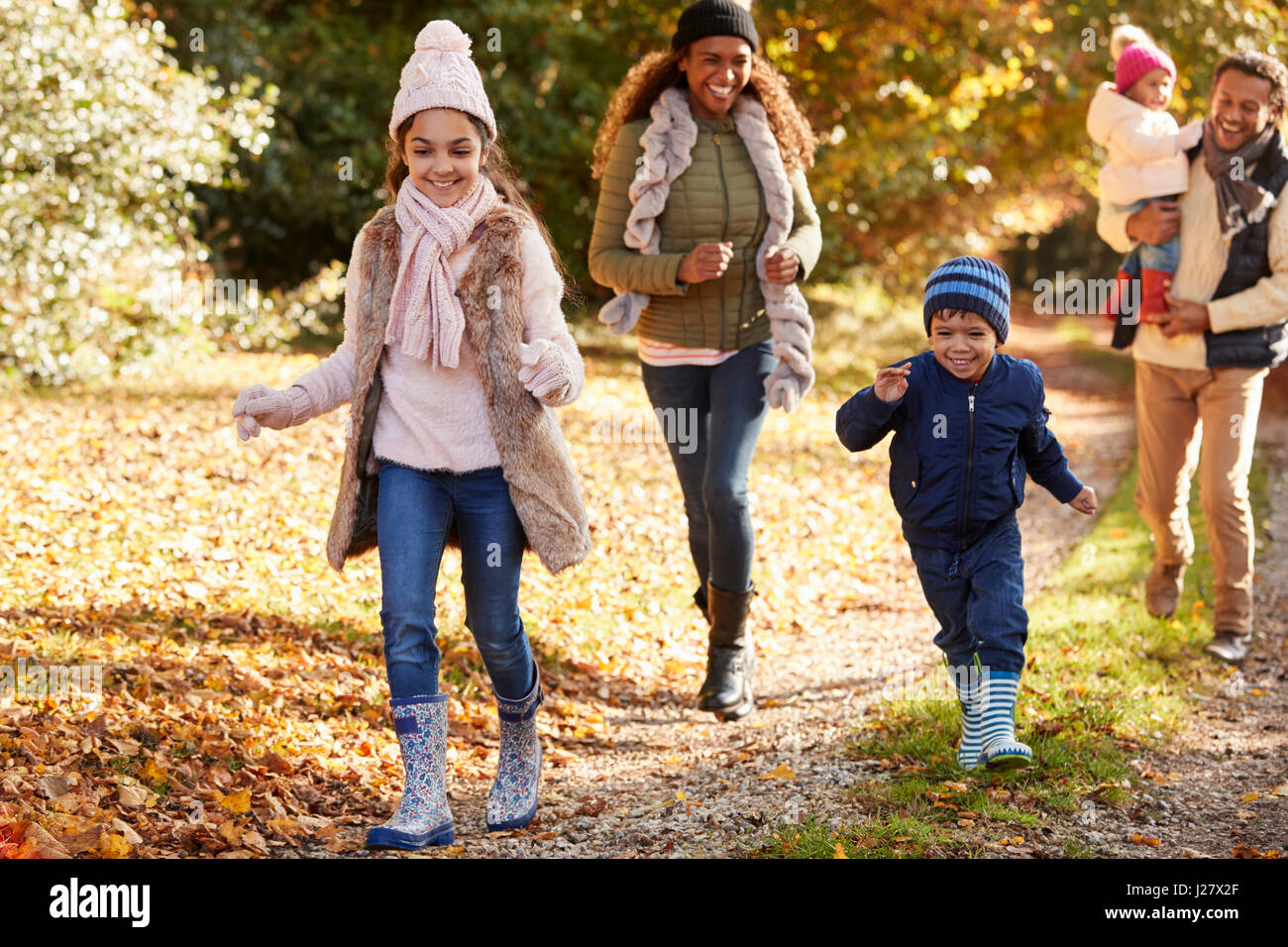 Family Running Along Path Through Autumn Countryside Stock Photo - Alamy