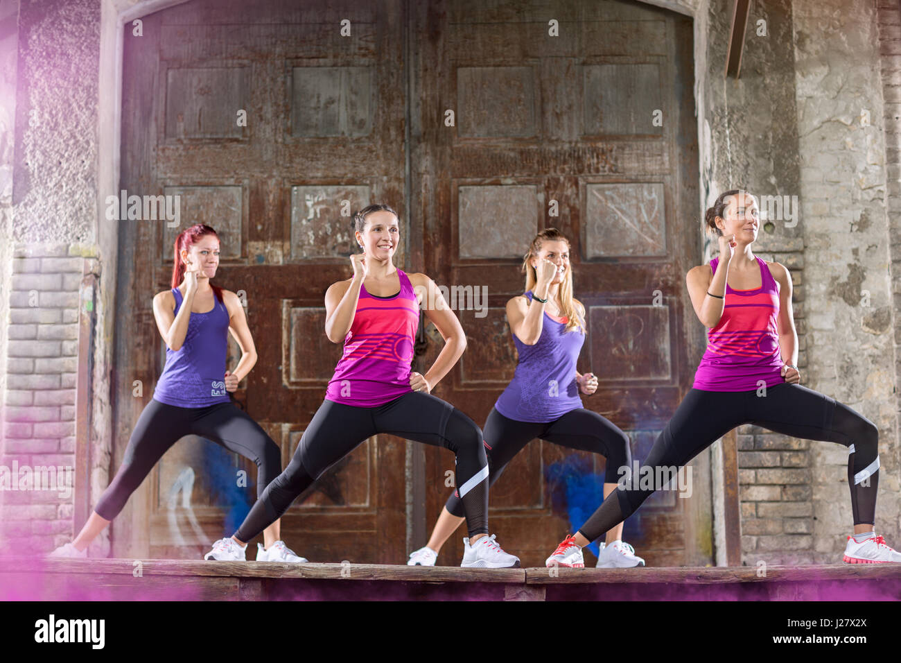 Young female in colorful athletic shirts keep fit shape exercising ...