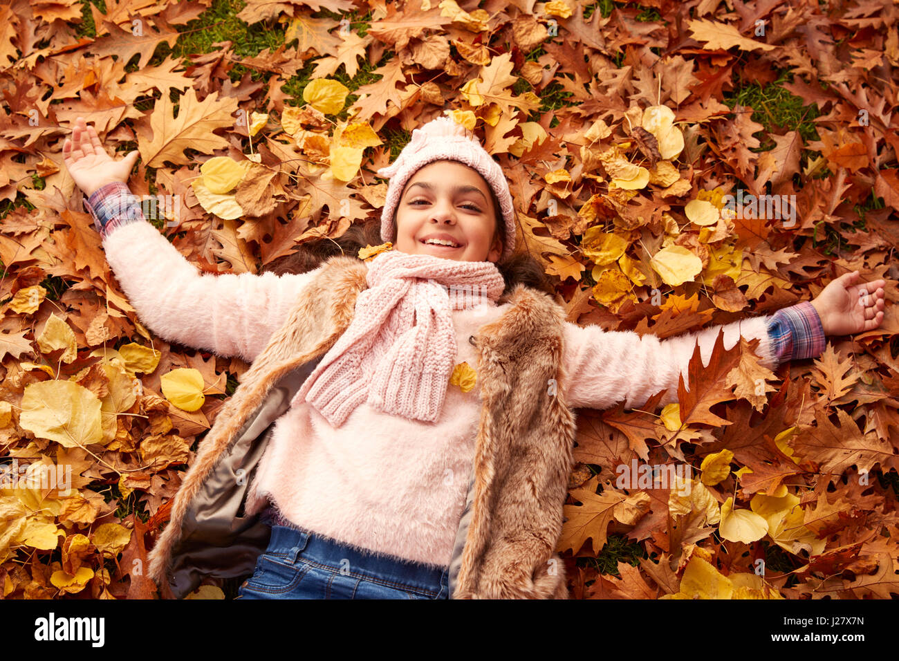 Overhead Portrait Of Girl Lying In Autumn Leaves Stock Photo - Alamy