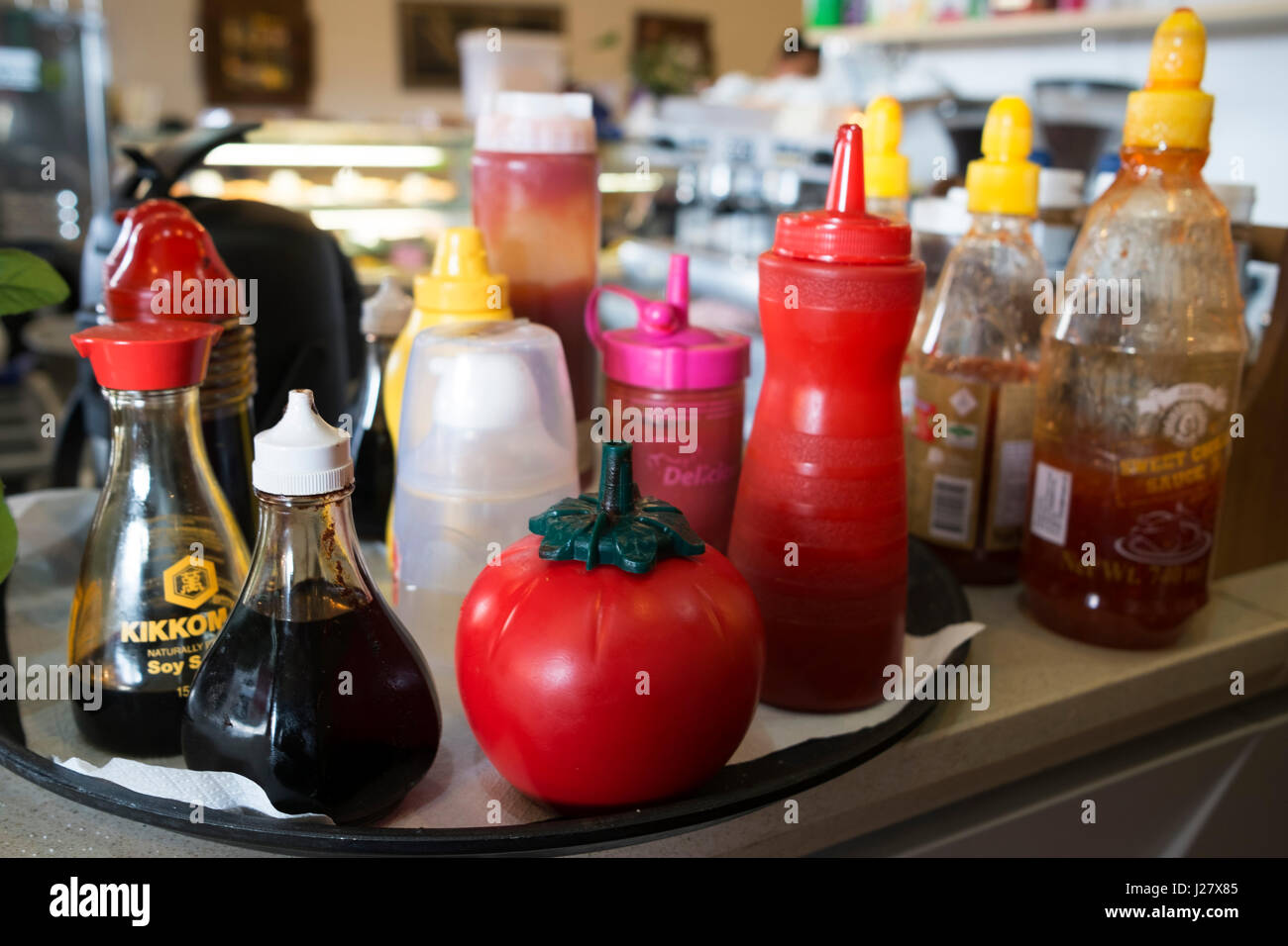 Tray of condiments and sauces in eclectic shaped bottles in a cafe in ...