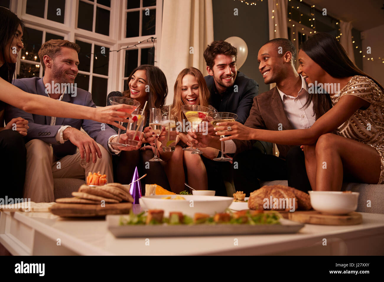 Friends Eating Snacks As They Celebrate At Party Together Stock Photo ...