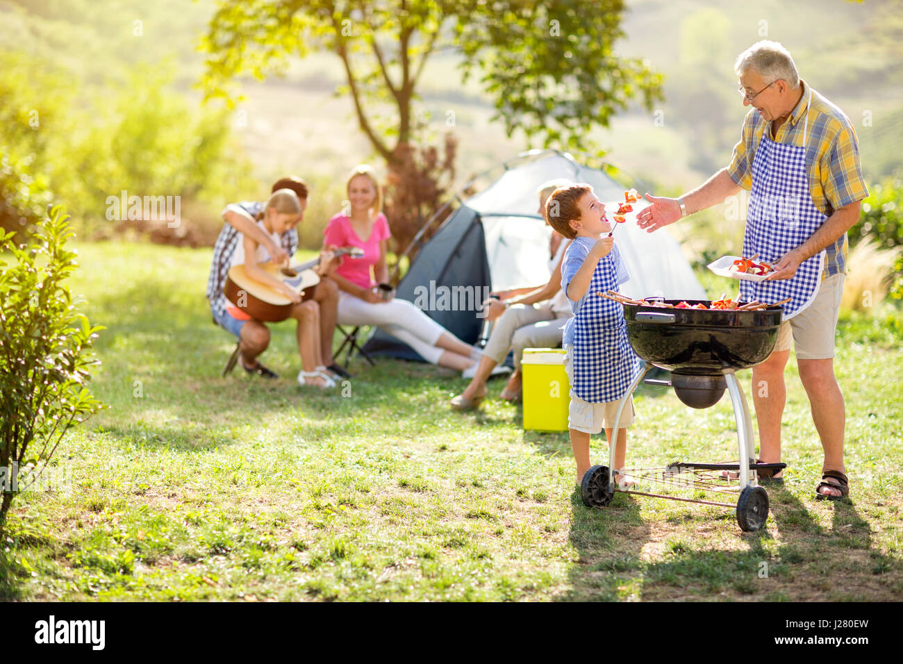 grandfather and grandson making barbecue for family Stock Photo - Alamy