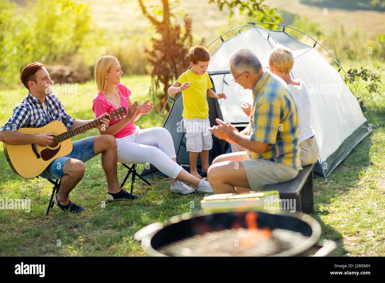 child singing with smiling family on camping Stock Photo - Alamy