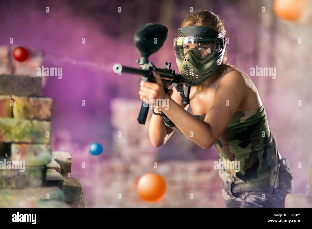 Paintball player shootout from marker gun Stock Photo - Alamy