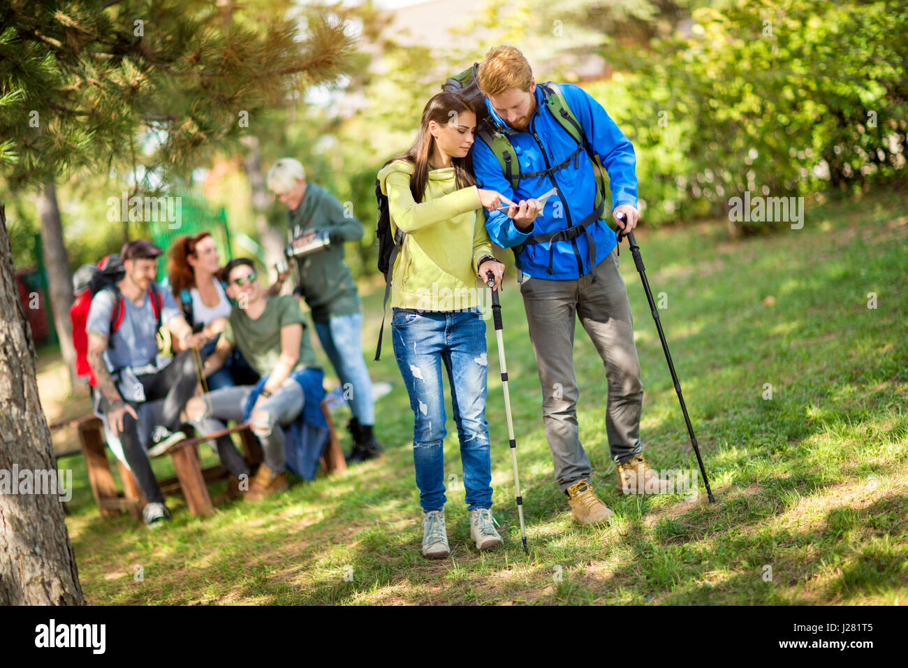 Girl and boy on break from walking in woods look at map Stock Photo - Alamy