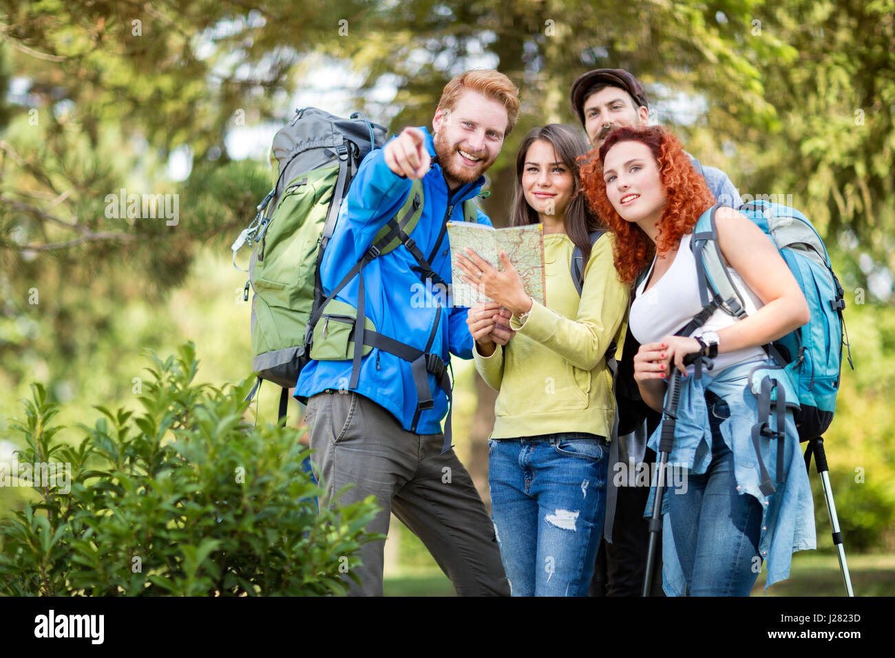 Cheerful hiking group show with finger destination in nature Stock ...