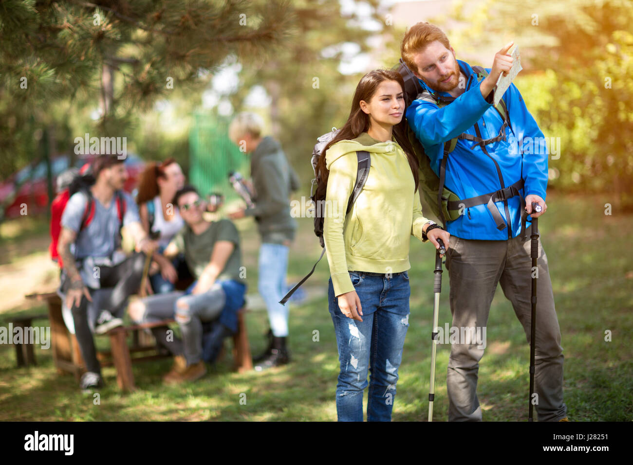 Male hiker show to his female friend path through wood Stock Photo - Alamy