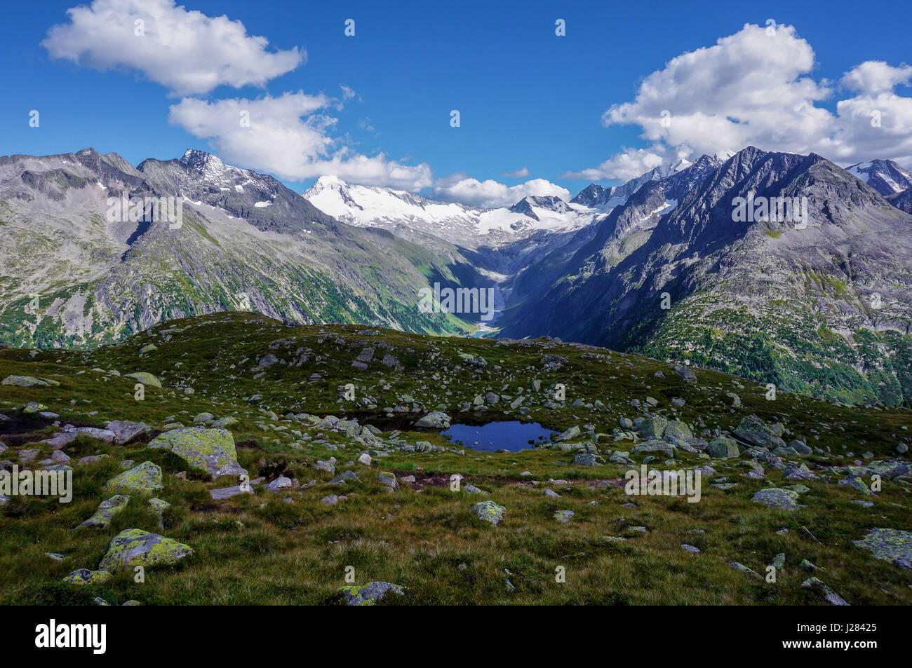 Small mountain lake with snow capped mountains and glacial valley in ...
