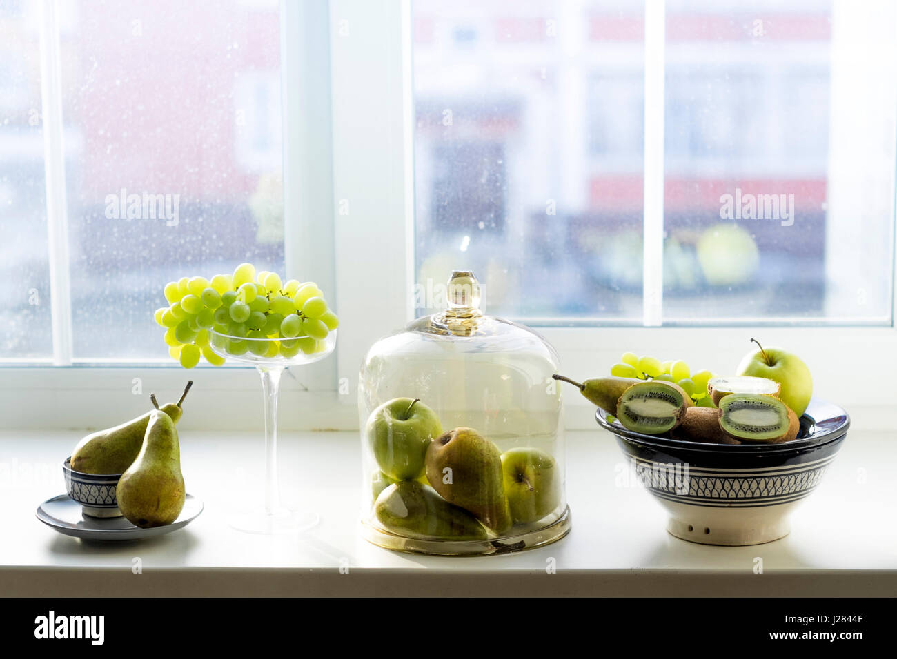 Various fruits in containers on window sill Stock Photo - Alamy
