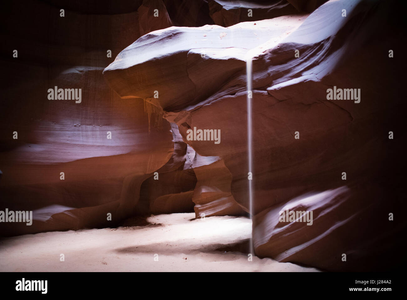 Sand falling over rock formation in cave at Antelope Canyon Stock Photo ...