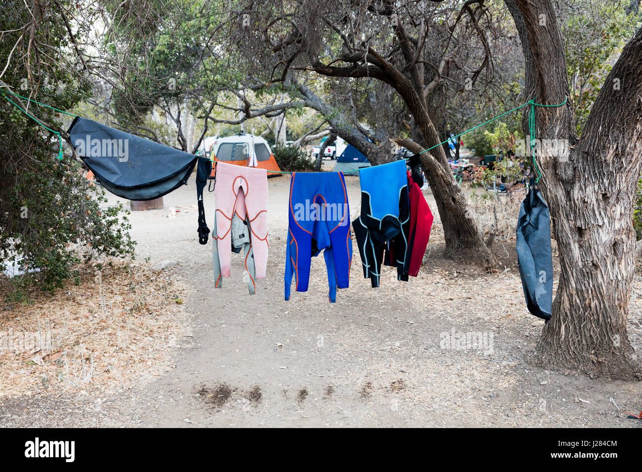 Wetsuits drying on clothesline at campsite Stock Photo - Alamy
