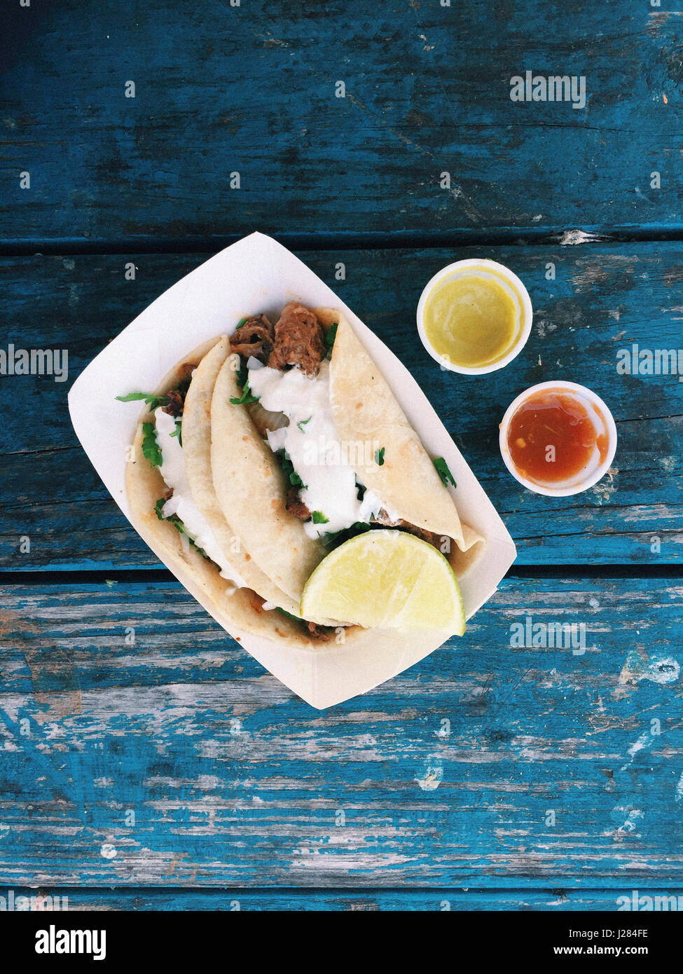 Overhead view of food in plate with condiments on wooden table Stock ...