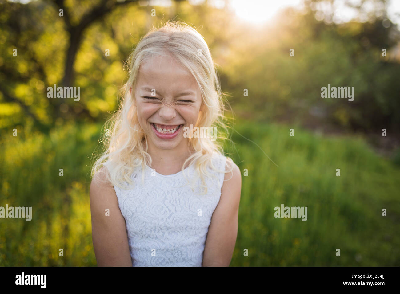 Cheerful girl standing on field in park Stock Photo - Alamy