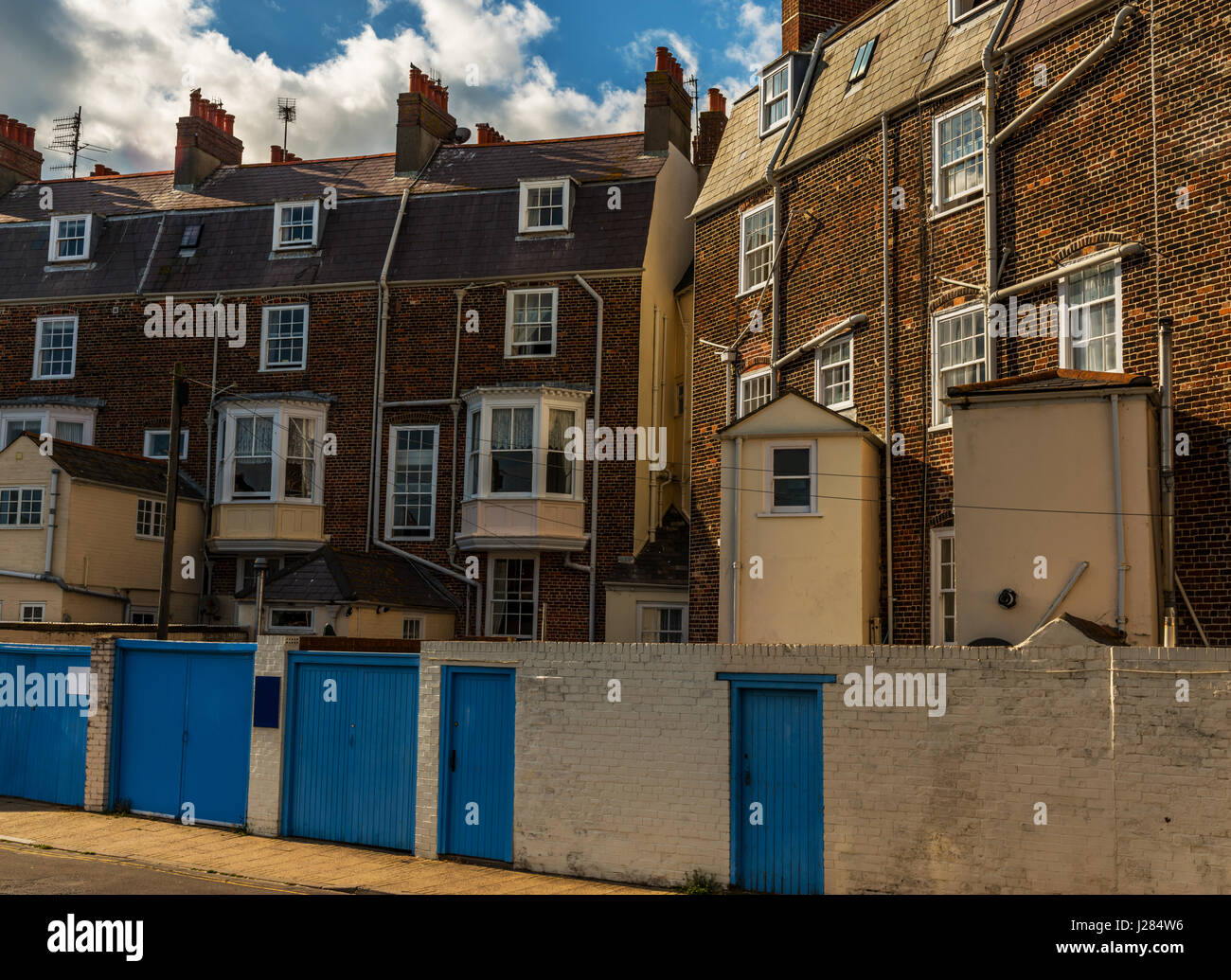 Typical English buildings, red brick buildings, tall wall and blue ...