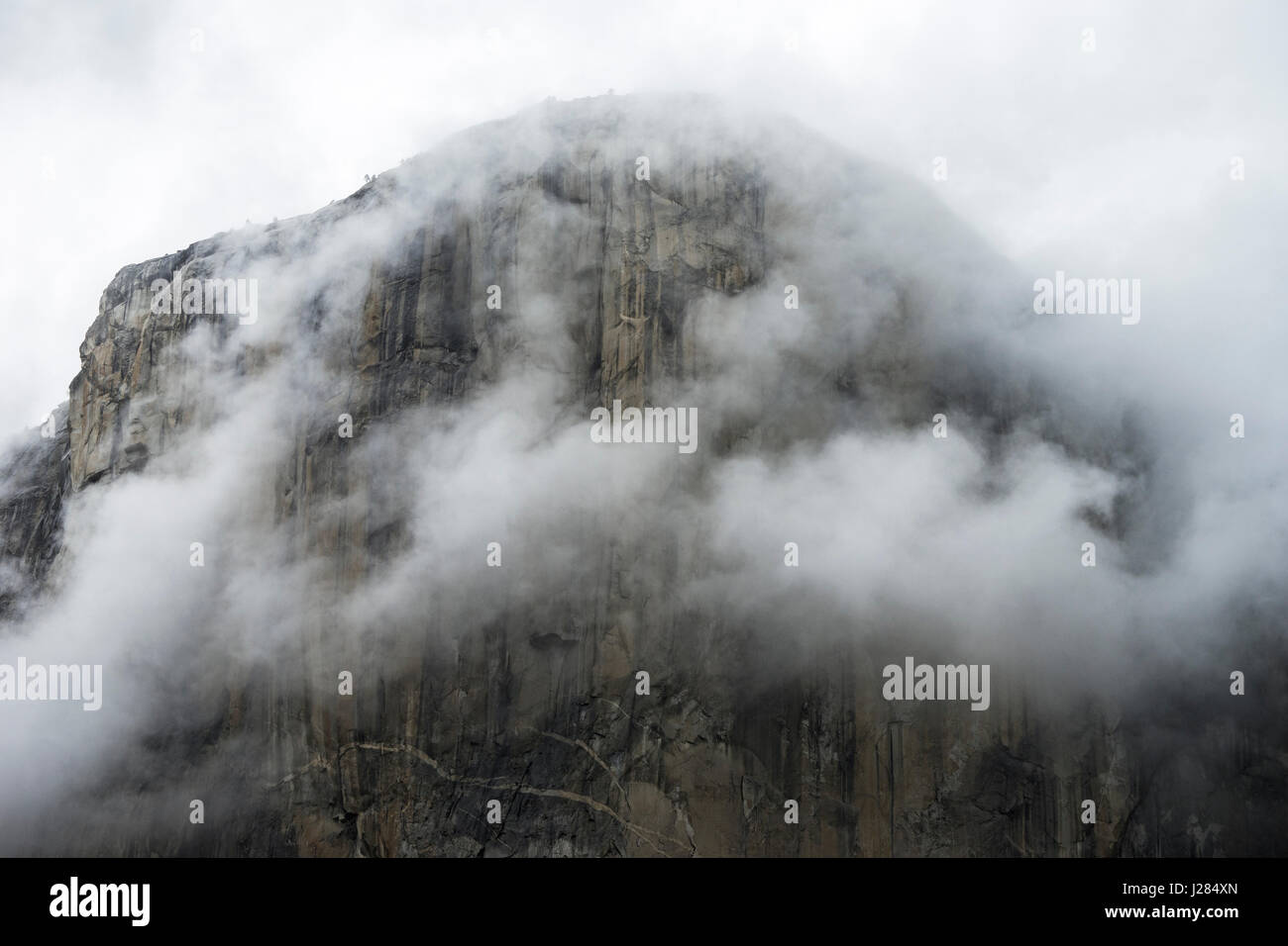 Low angle view of cliff covered with clouds at Yosemite National Park ...