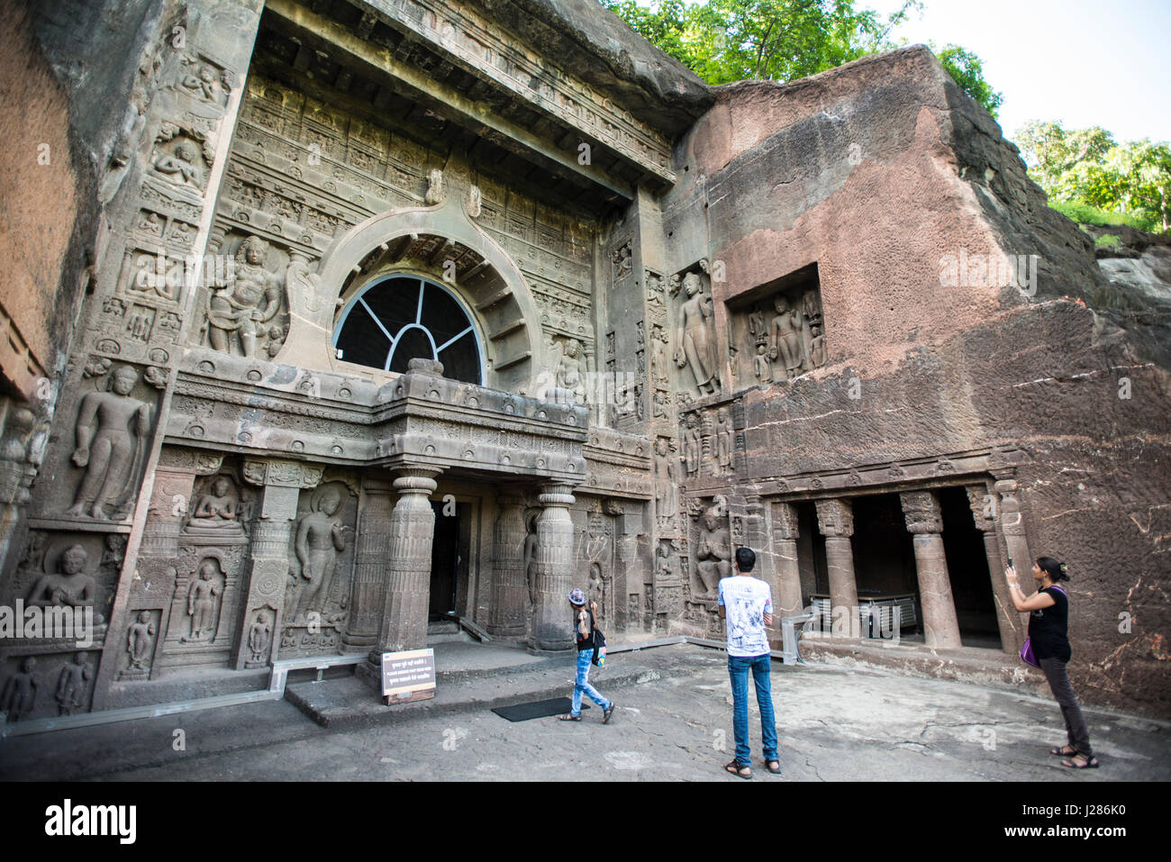 Tourists admire and take photos of one of the largest cave entrances at ...