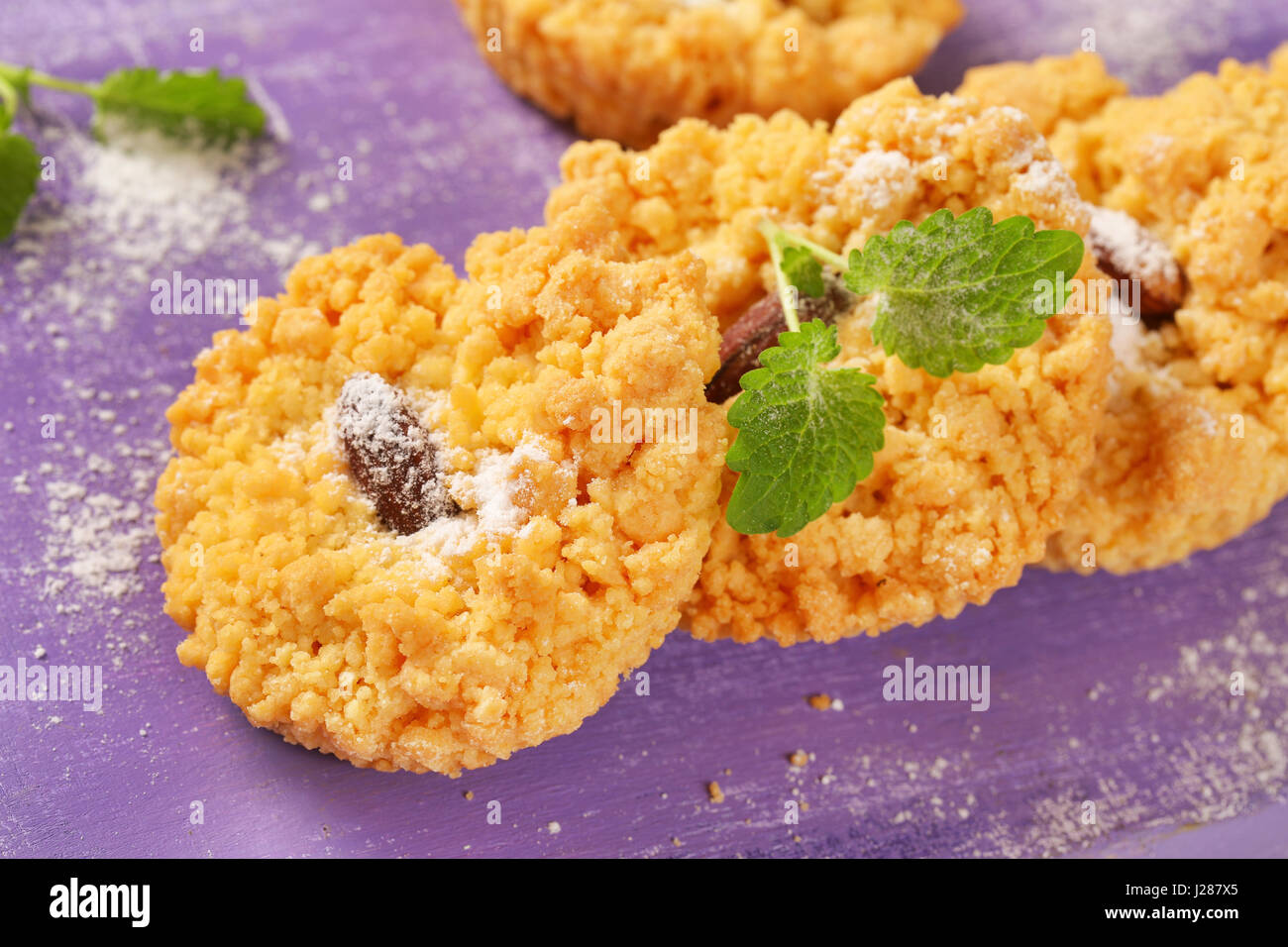 Small almond cookies on purple background Stock Photo - Alamy