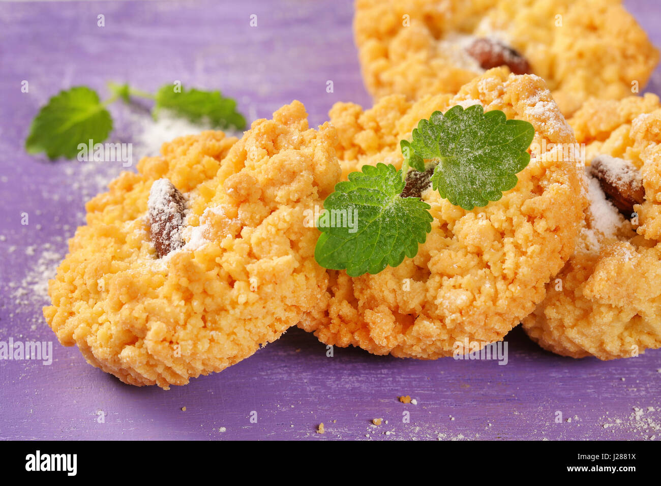Small almond cookies on purple background Stock Photo - Alamy