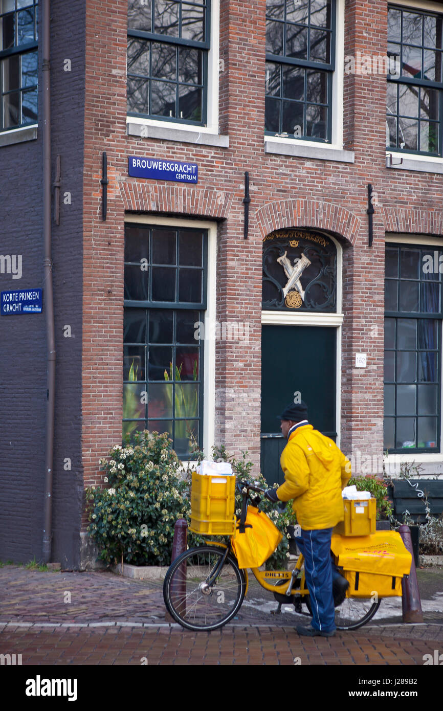 Holland, Amsterdam, postman delivering mails in the historical centre ...