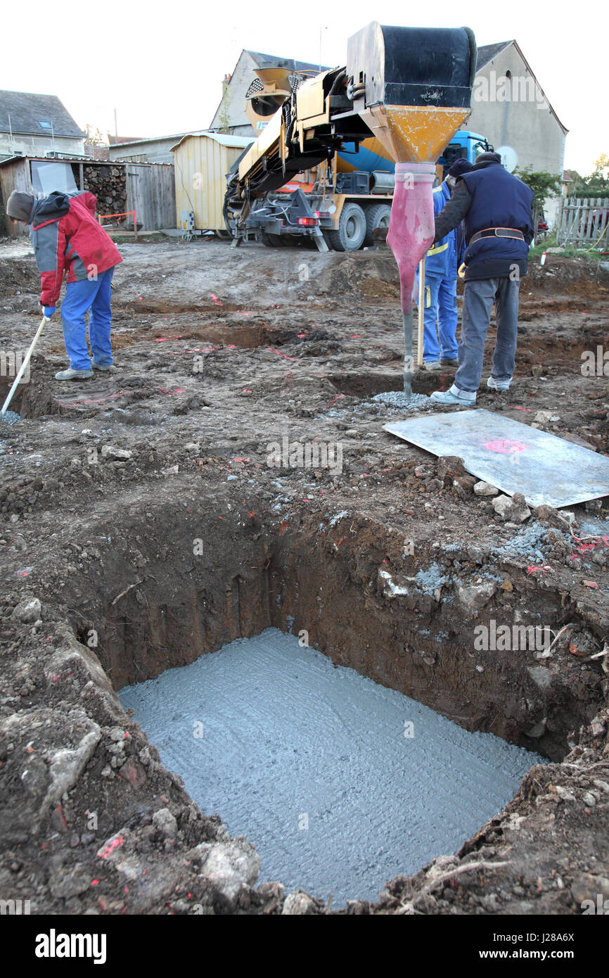 House building, pouring of two concrete footings for the house's ...