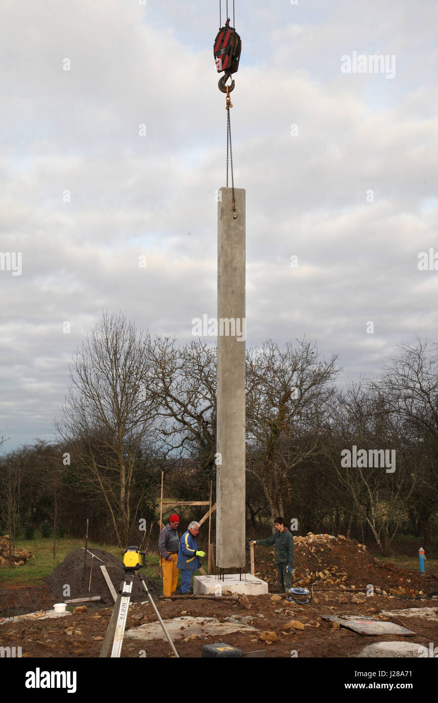 House building, installation of a concrete post on a concrete footing ...