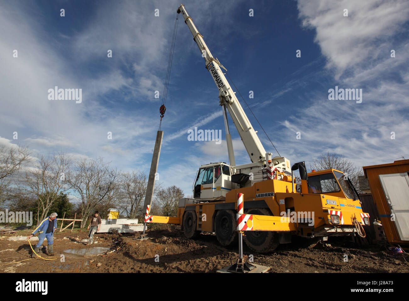 House building, installation of a concrete beam on a concrete footing ...