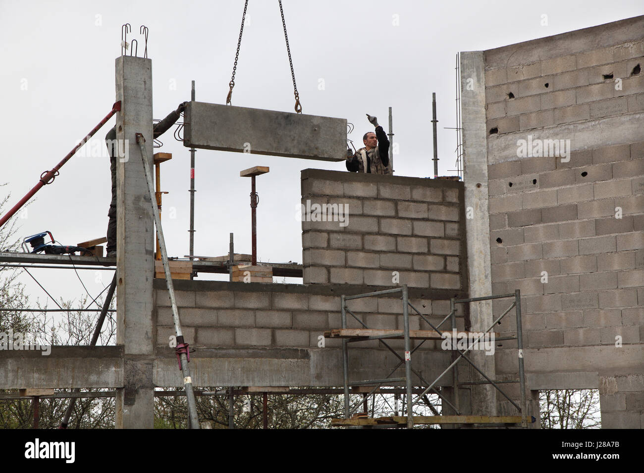 House building, installation of a concrete post for the raising of the ...